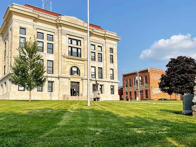 That gorgeous limestone courthouse facade catches the morning sun beautifully, with a vintage Coca-Cola ghost sign nearby adding a perfectly nostalgic finishing touch.