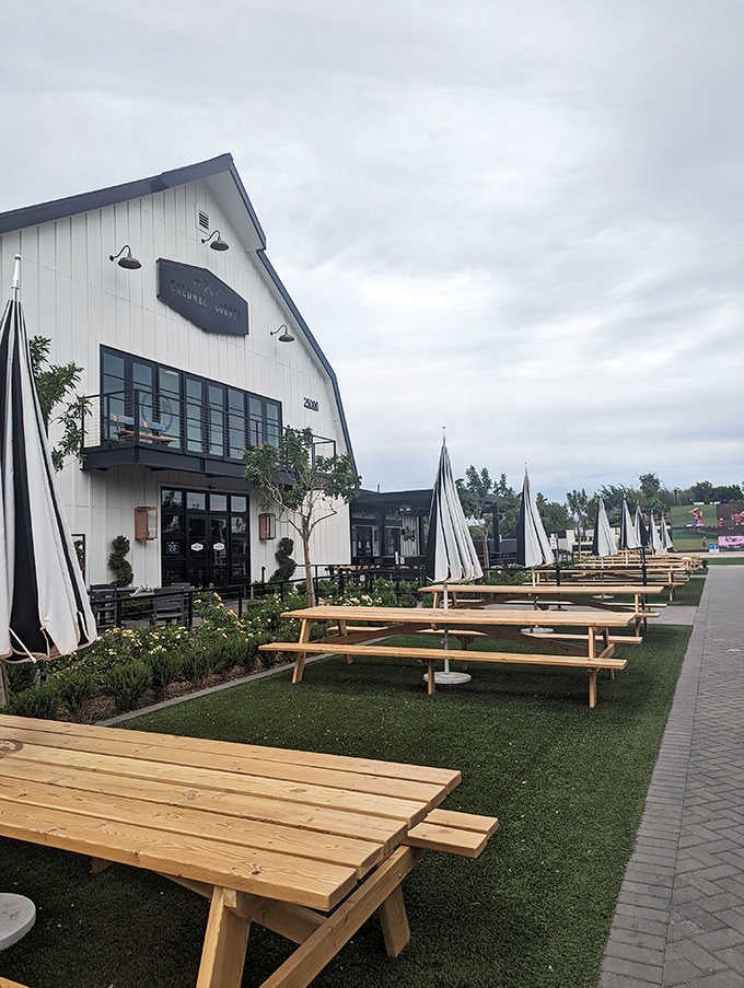 Modern barn architecture meets classic BBQ tradition in this inviting space with fresh picnic table seating everywhere.