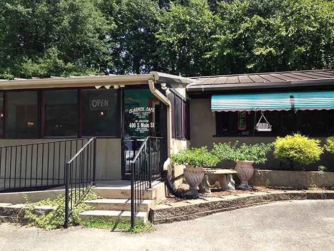 Lush summer greenery frames the "Open" sign at Claunch Cafe like nature itself is welcoming you through the front door.