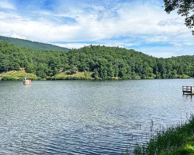 A wooden dock juts into Douthat Lake's calm waters, quietly suggesting you sit down and stay a while.