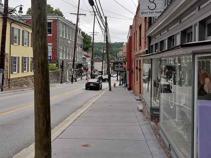 The Ellicott City sign anchors a quiet stretch of sidewalk where stone buildings and tucked-away shops reward anyone patient enough to wander slowly.