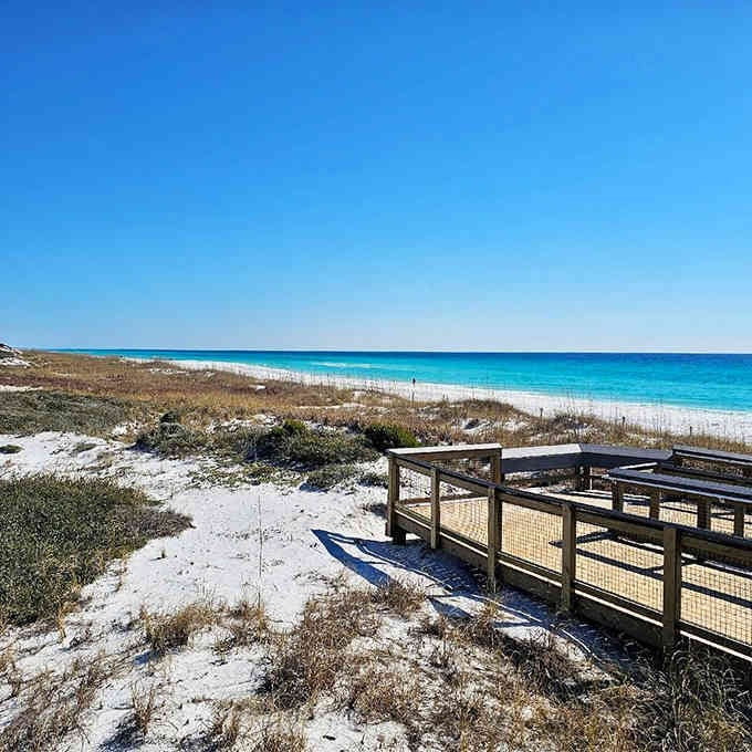 The wooden boardwalk leads straight to sugar-white sand and emerald waters that'll make you forget every beach you've seen before.