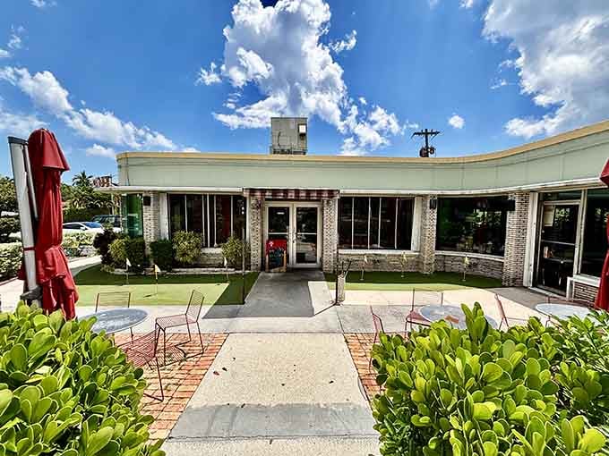 The curved mid-century facade, brick accents, and red patio umbrellas give Howley's the relaxed charm of a neighborhood treasure.