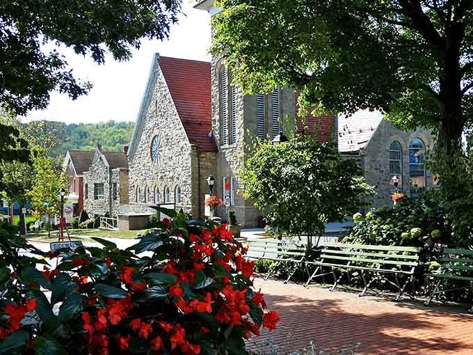 Red begonias, a stone church, and a brick walkway in Ligonier combine into a scene so lovely it almost feels unfair.
