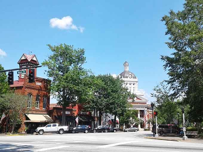 Classic courthouse architecture anchored by mature oaks creates the quintessential Southern town square where time moves at conversation speed.
