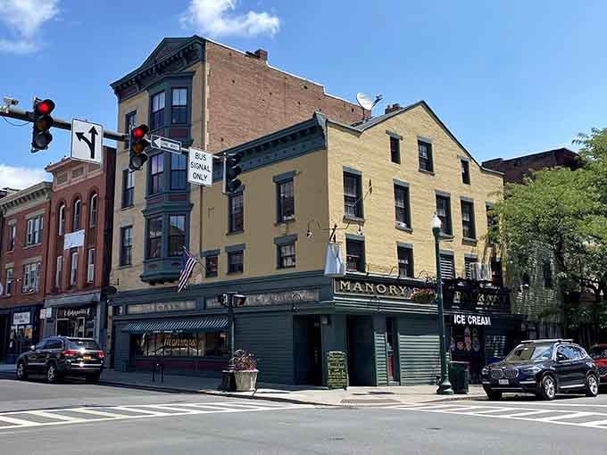 Sunny skies, a busy corner, and Manory's anchoring the whole block like it's been holding downtown Troy together for decades.