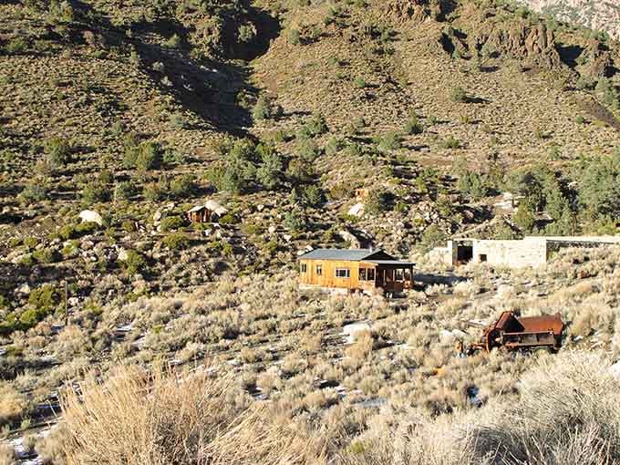 Scattered cabins and rusted equipment cling to a steep brushy slope, stubborn as the miners who once lived there.