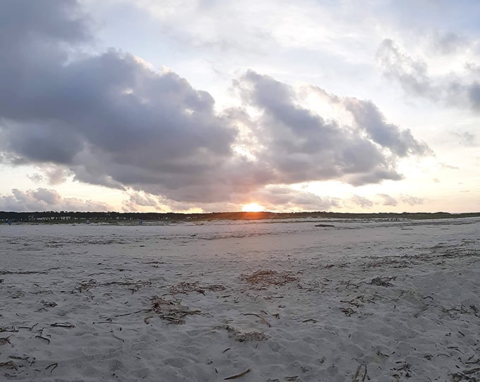Sunset paints the beach in soft pastels while dramatic clouds add theater to this peaceful evening performance scene.