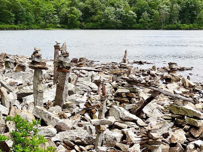 Visitors have stacked stone cairns along the rocky shoreline, turning the water's edge into an accidental outdoor art gallery.