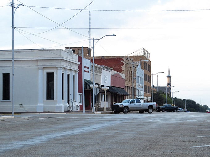 A church steeple peeks above Sweetwater's roofline as pickup trucks line the street, reminding you that some things never change.