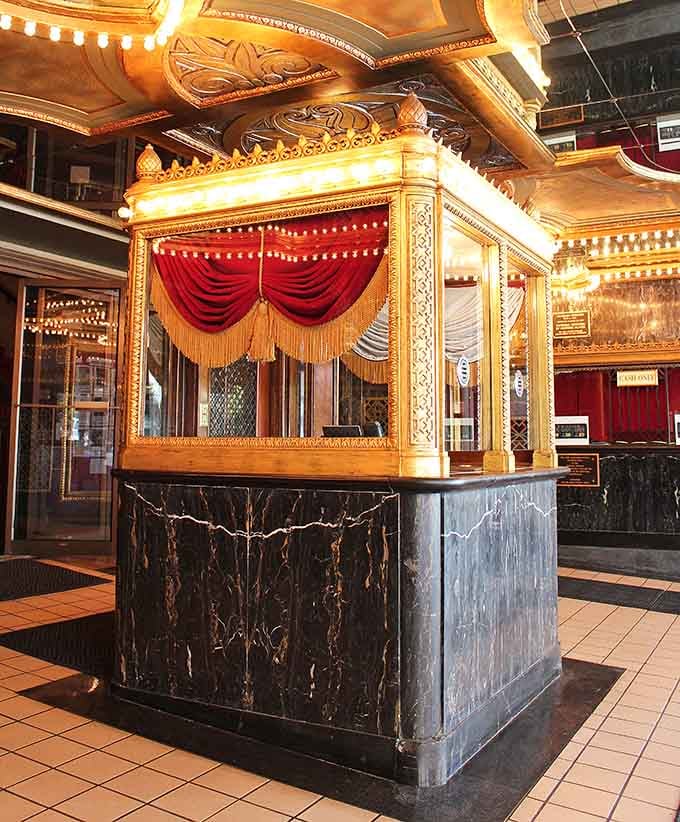 The original ticket booth, dressed in gold leaf and red velvet, sets the tone before you've even found your seat.