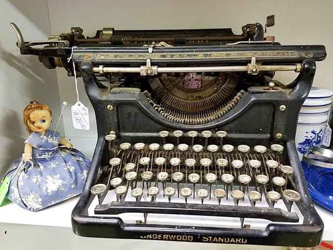 An Underwood Standard typewriter that outlasted entire industries, sitting quietly next to a vintage doll with nowhere to be.