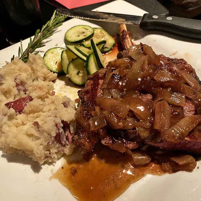 A bone-in cut with caramelized onions, mashed potatoes, and saut&eacute;ed zucchini &mdash; this plate means serious business, and it knows it.