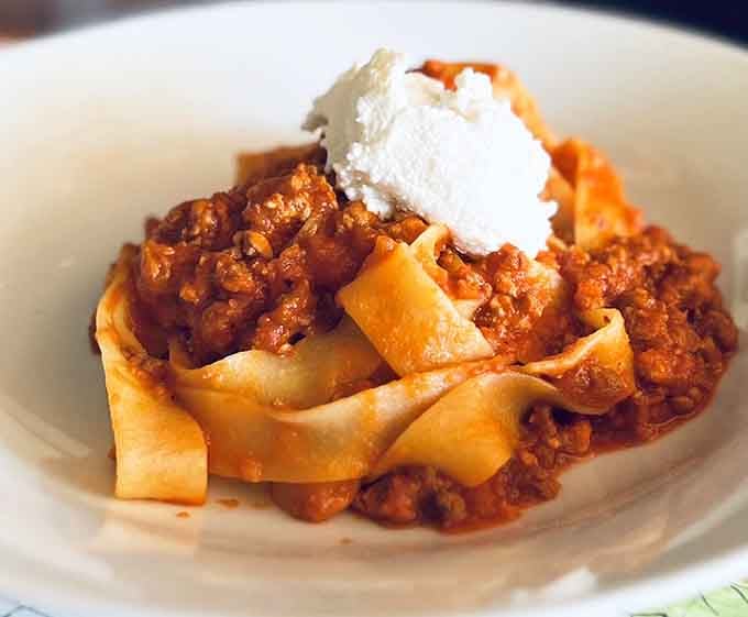Ribbons of pappardelle buried under bolognese and crowned with ricotta, this dish is a pasta lover's quiet victory lap.