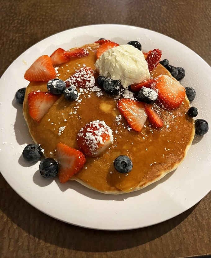 Fluffy pancakes crowned with fresh strawberries, blueberries, powdered sugar, and whipped cream. Breakfast just became the best meal of the day.