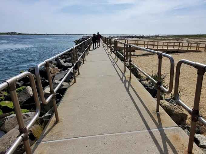 The jetty walkway stretches out toward open water, flanked by steel railings and the kind of views that stop conversations cold.
