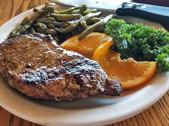 A perfectly grilled steak with green beans and fresh orange slices. Simple, honest, and absolutely no apologies needed.
