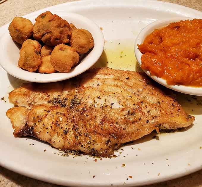 A beautifully broiled fillet with fried okra and sweet potatoes on the side, Southern comfort food at its most confident.