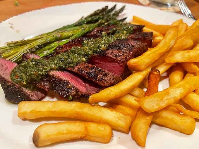 Sliced flank steak cooked to a beautiful pink, draped in herb sauce — Warren County never looked this good on a plate.