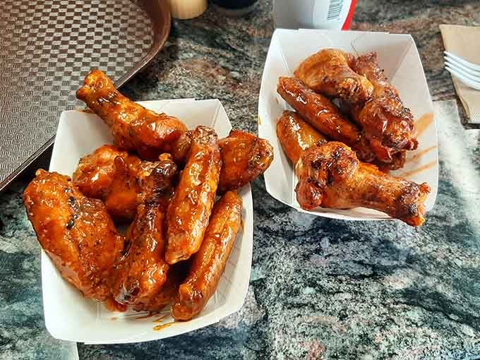 Two baskets of glossy, sauced wings sitting side by side, like the best kind of problem you've ever had to solve.