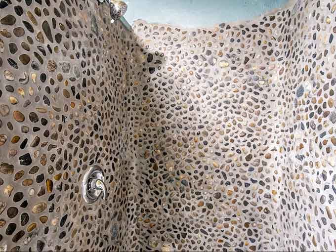 River rock shower walls that would cost a fortune elsewhere come standard when you're inside actual geology.