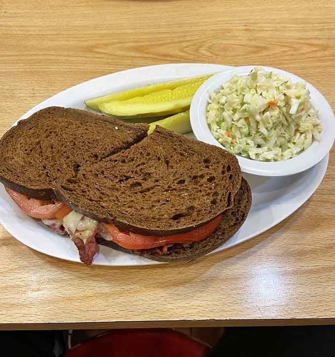 Dark rye, hot pastrami, coleslaw, and a pickle spear, this plate is a love letter to the classic deli tradition.
