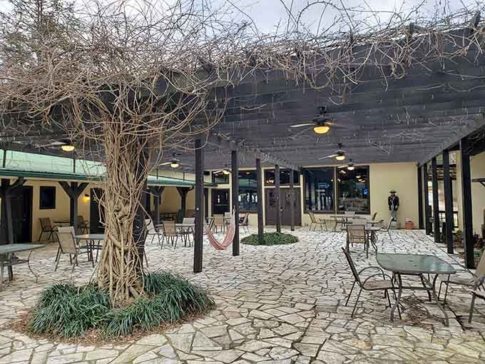 Ceiling fans, stone pavers, and bare winter vines overhead. This patio has a quiet magic that hits differently in every season.