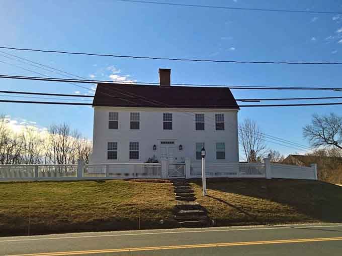 The Captain Samuel Rockwell House sits behind a white picket fence like it knows exactly how good it looks.