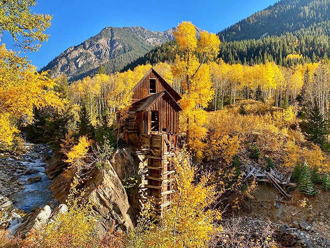 Fall colors explode around the old structure, proving nature has better taste than any Instagram filter.