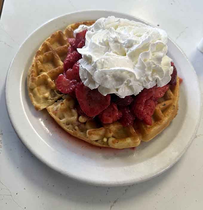 A Belgium waffle buried under strawberries and whipped cream. This is not breakfast, this is a celebration.