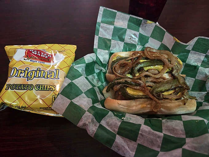 A Koegel Vienna loaded with caramelized onions and peppers, sitting next to a bag of Better Made chips. Michigan on a plate.