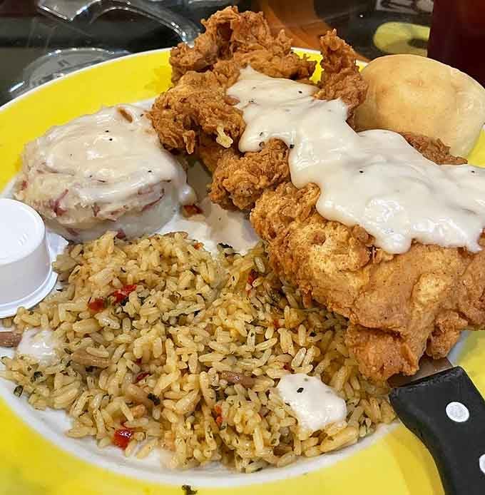 Crispy fried chicken smothered in white gravy, served with seasoned rice and a warm roll. Southern cooking at its most generous.