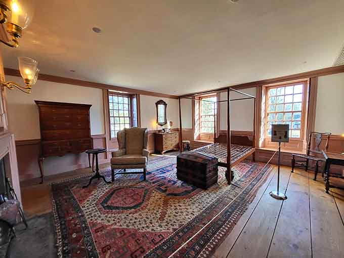 This spacious bedroom features a four-poster bed and rugs that have seen more history than your encyclopedia set.
