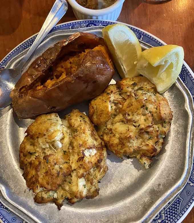 Two golden crab cakes, a sweet potato, and lemon wedges. Simple, honest, and exactly what a good meal should look like.