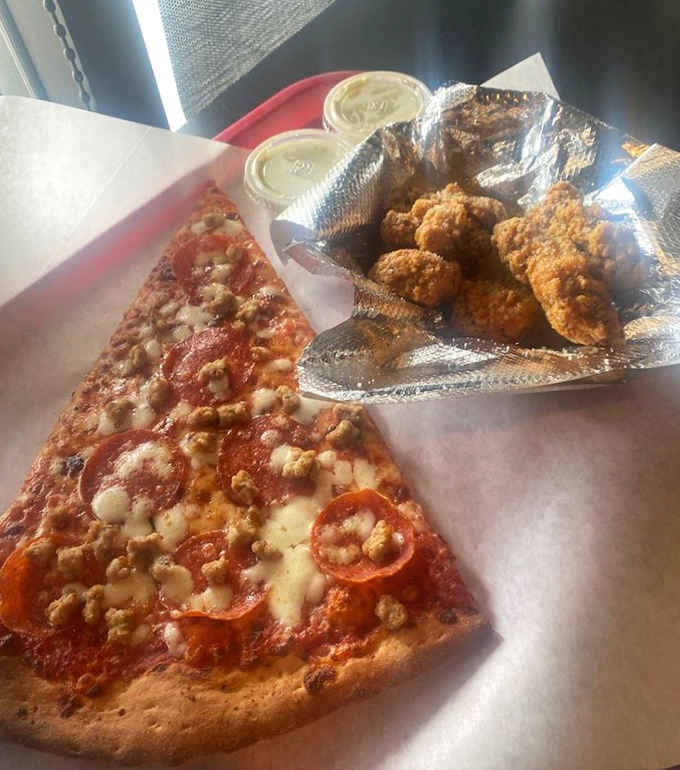 Crispy boneless wings beside a loaded giant slice. Two heavyweights on one tray, and nobody's complaining about the company.