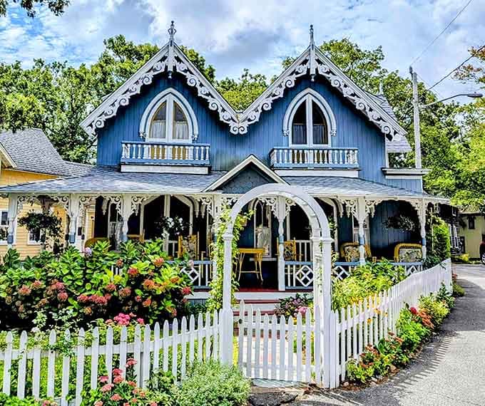 Deep blue walls, white scrollwork, and a white picket fence. This cottage is the whole package.