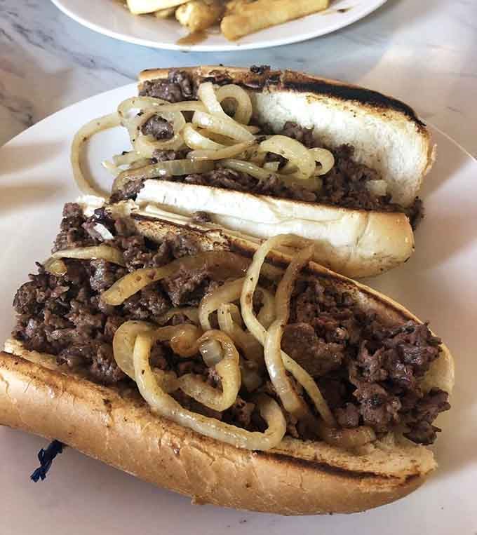 Two cheesesteaks loaded with savory beef and sweet caramelized onions, sharing was clearly never part of the plan here.