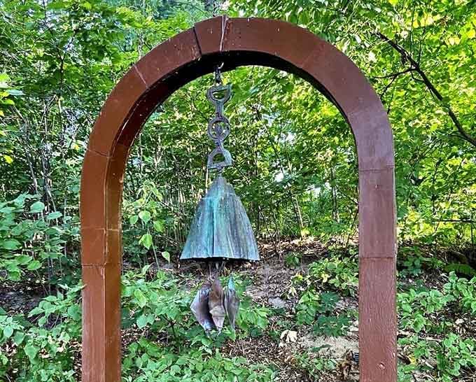 A weathered bronze bell hanging beneath a rustic arch, quietly waiting for someone to notice how beautiful it is.