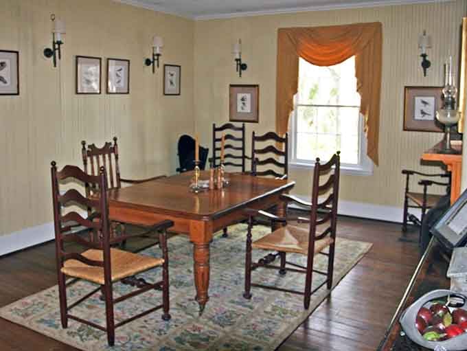 Ladder-back chairs, warm wood, and candlelight. This dining room makes every meal feel like a scene from a period drama.