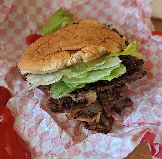 Crispy edges, fresh lettuce, and caramelized onions peeking out. This burger isn't trying to impress anyone, it just does.