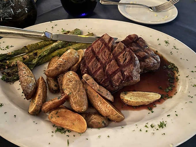 A perfectly seared steak with roasted potatoes and asparagus, plated like someone genuinely cares about your happiness.