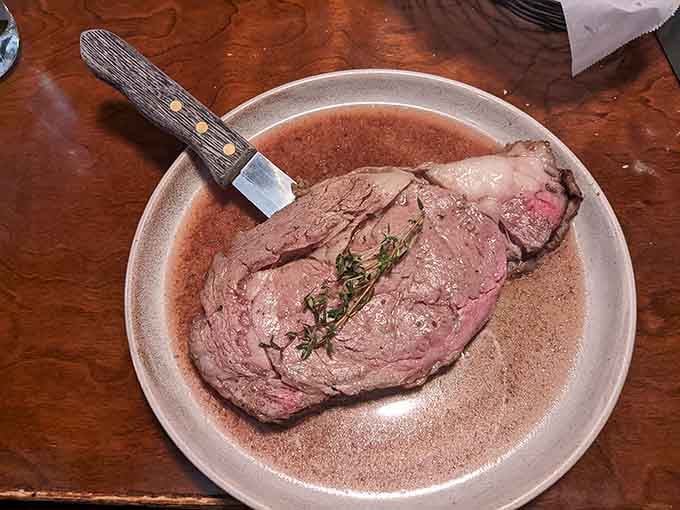 A steak knife planted in prime rib like a flag claiming delicious territory. No further explanation needed whatsoever.