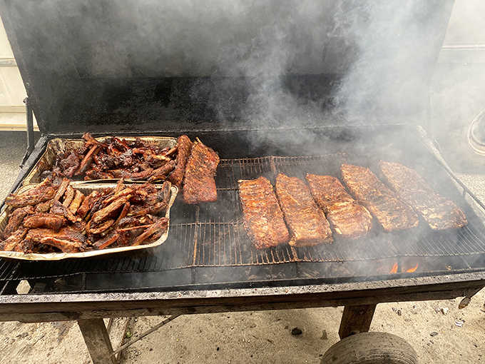 Racks of ribs on a real wood smoker, billowing smoke like a locomotive headed straight for your appetite.