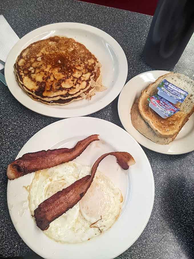 Eggs, bacon, pancakes, and toast. A complete morning spread that makes every other breakfast feel underdressed.