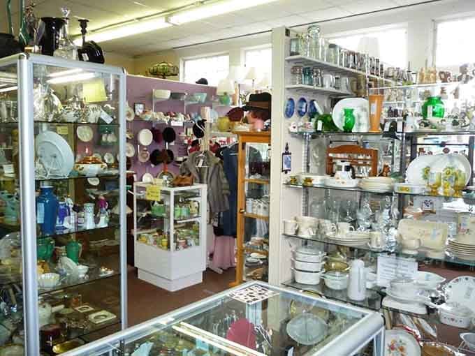 Rows of colorful glassware and vintage hats line the shelves like a very well-dressed time capsule.