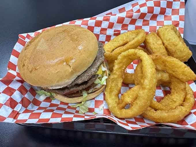 A double burger stacked next to golden onion rings. This tray arrived and the whole table went quiet.