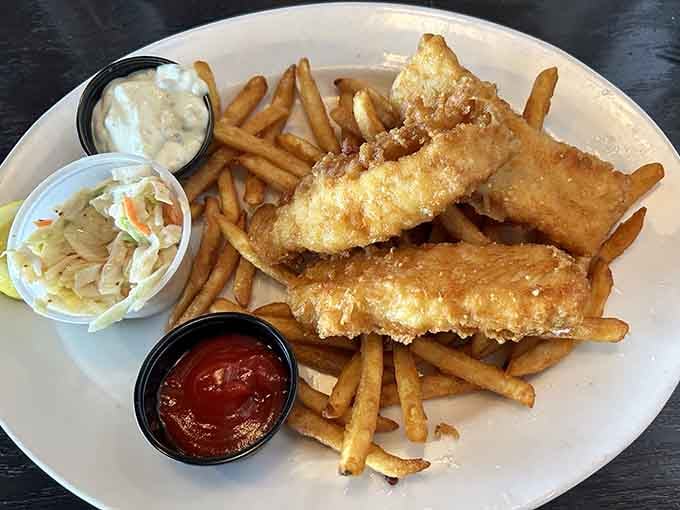 Crispy, golden-fried fish with coleslaw, fries, and dipping sauces, a Friday night classic that deserves a standing ovation.