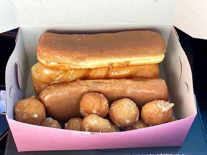 A pink box filled with maple bars and donut holes is basically a portable happiness delivery system for any occasion.