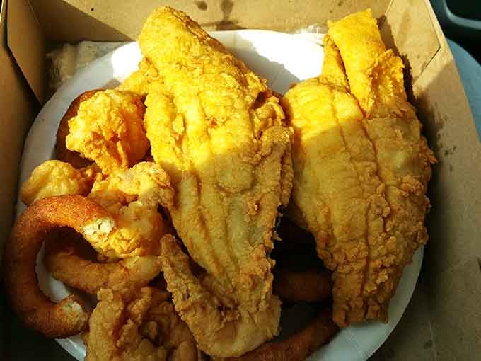Golden catfish, crispy shrimp, and onion rings packed together. This takeout box is basically a greatest hits album.