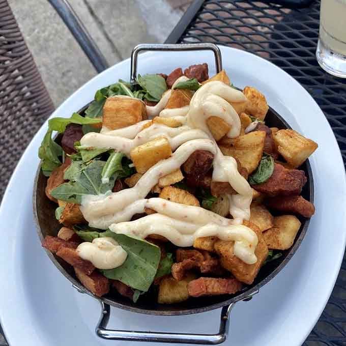 Crispy yuca and chicharrónes piled high with greens and a creamy drizzle. Snack time has officially been redefined here.